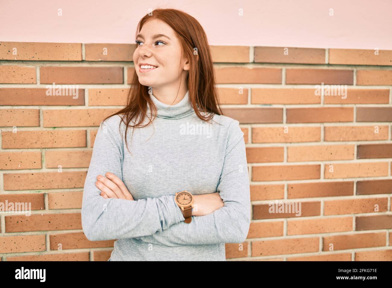 Young irish teenager girl smiling happy leaning on the wall at the city ...