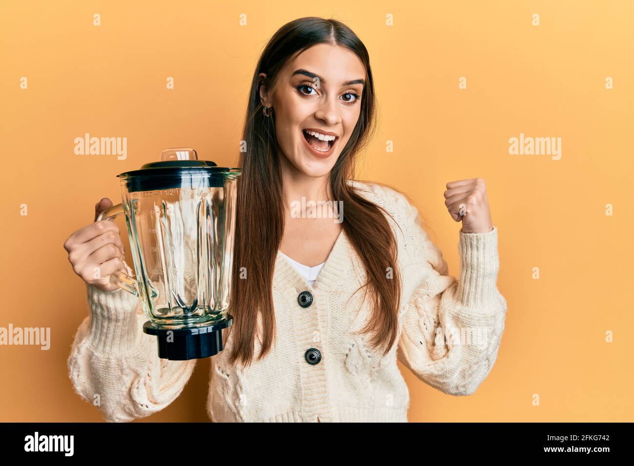 Beautiful brunette young woman holding food processor mixer machine ...