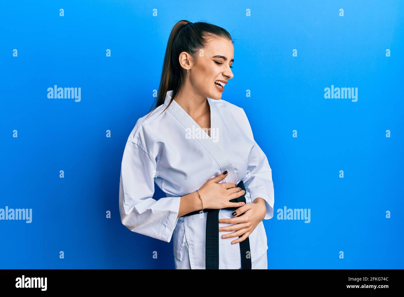 Beautiful brunette young woman wearing karate fighter uniform with ...