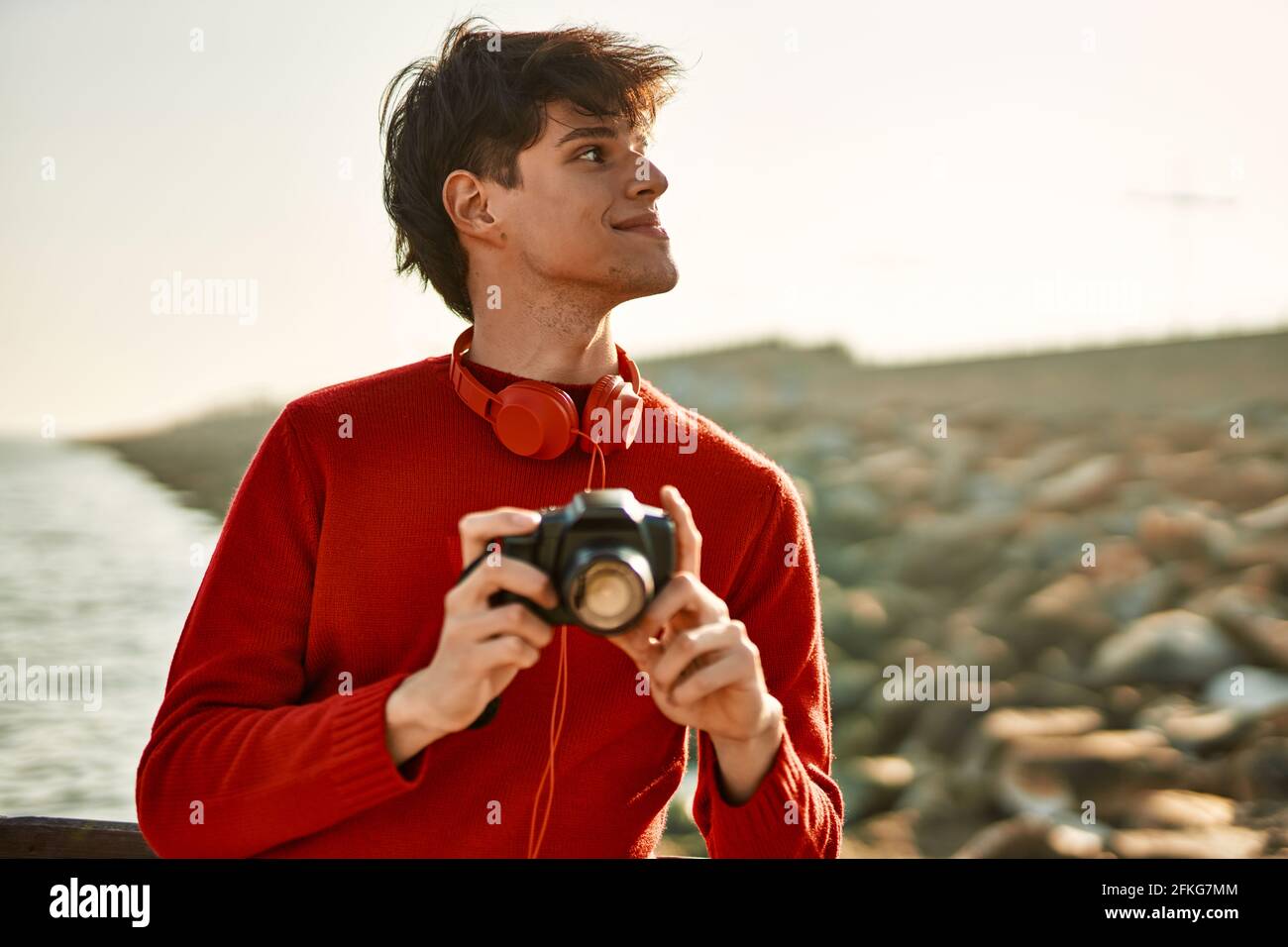 Young hispanic man smiling happy using reflex camera at the beach Stock ...