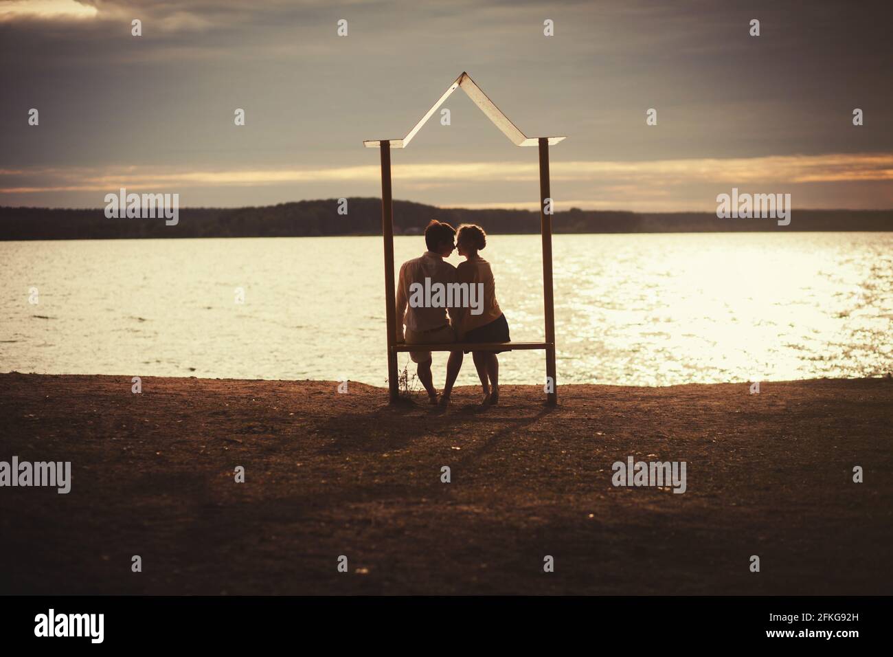 romantic couple sitting together at sunset Stock Photo - Alamy