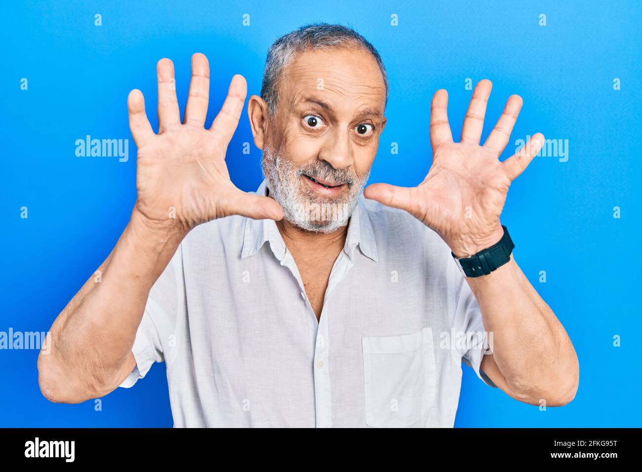 Handsome senior man with beard wearing casual white shirt showing and ...