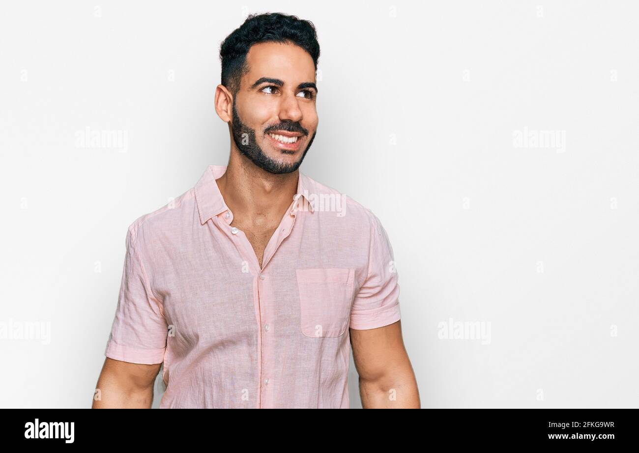 Hispanic man with beard wearing casual shirt looking away to side with ...