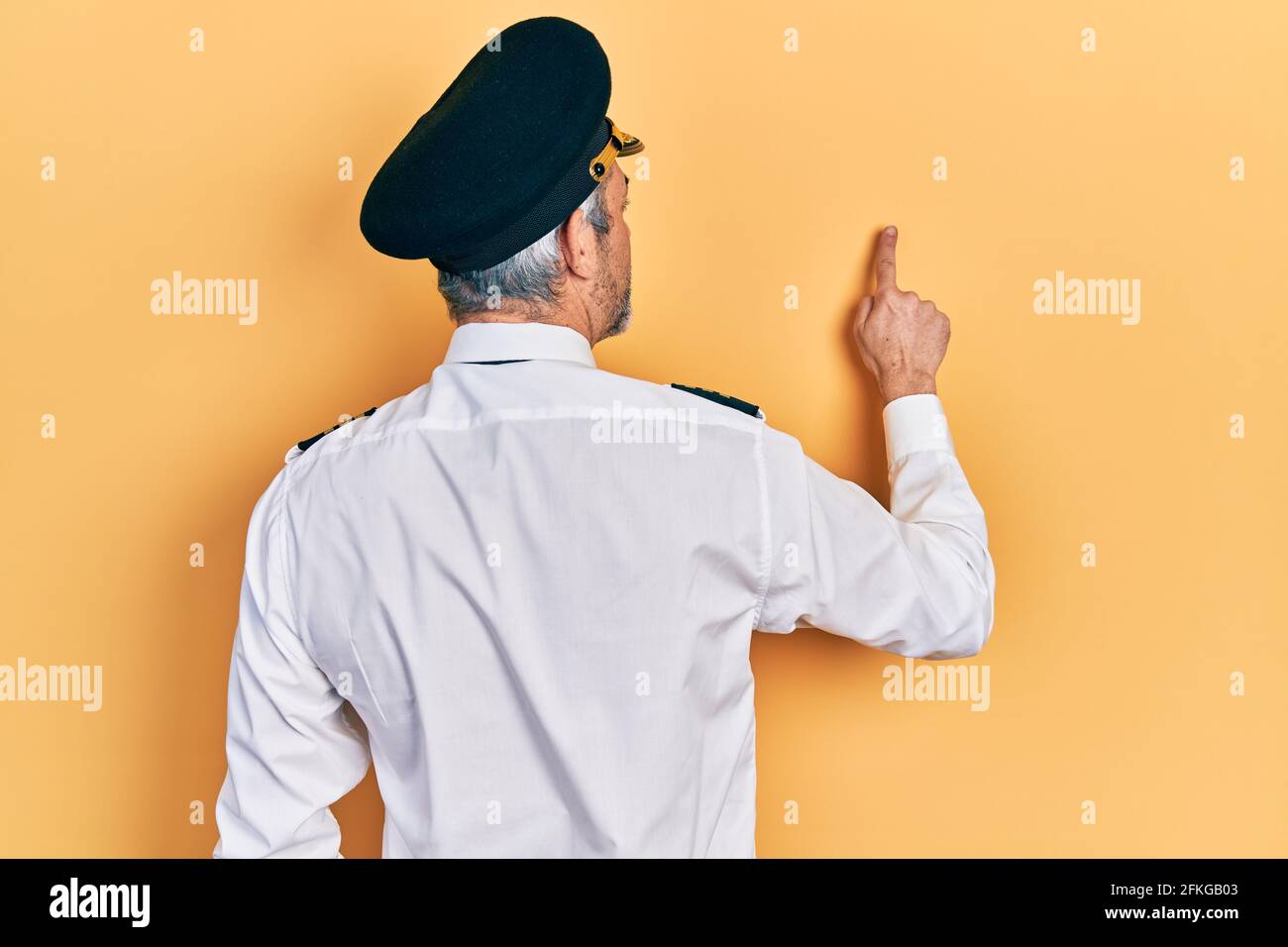 Handsome middle age man with grey hair wearing airplane pilot uniform ...
