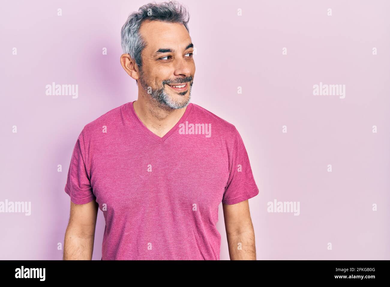 Handsome middle age man with grey hair wearing casual pink t shirt ...