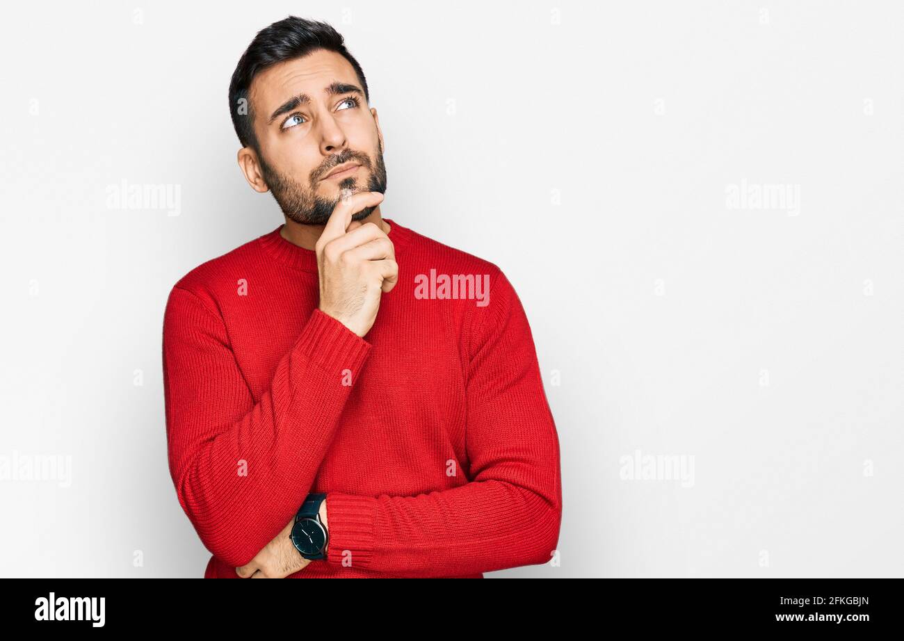 Young hispanic man wearing casual clothes with hand on chin thinking ...