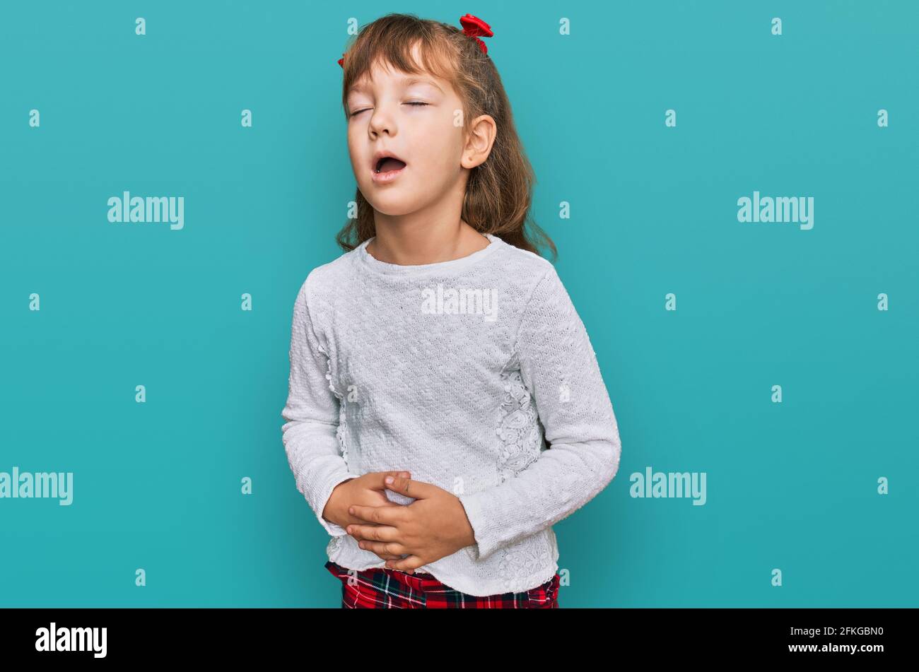 Little caucasian girl kid wearing casual clothes with hand on stomach ...