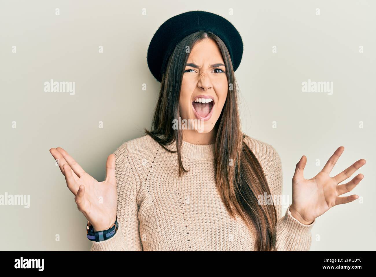 Young brunette woman wearing french look with beret crazy and mad ...