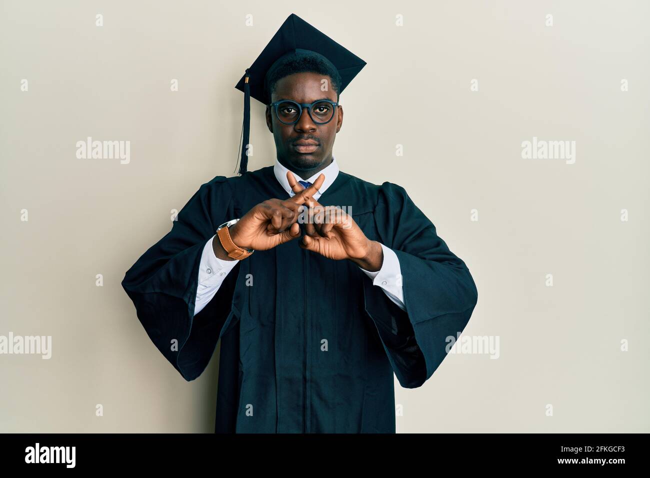 Handsome black man wearing graduation cap and ceremony robe rejection ...