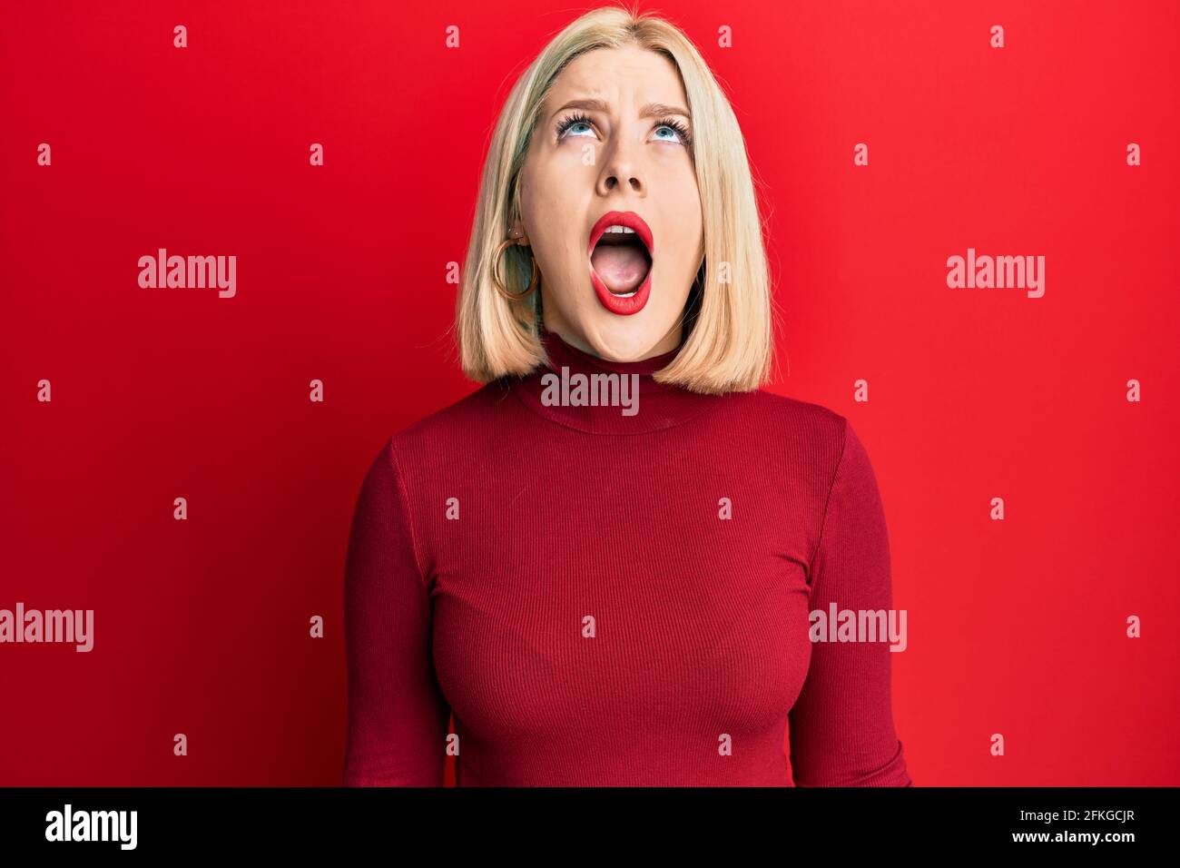 Young blonde woman wearing casual clothes angry and mad screaming ...