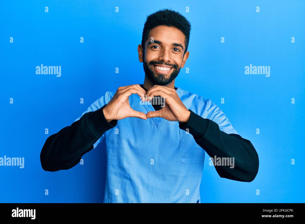 Handsome hispanic man with beard wearing blue male nurse uniform ...