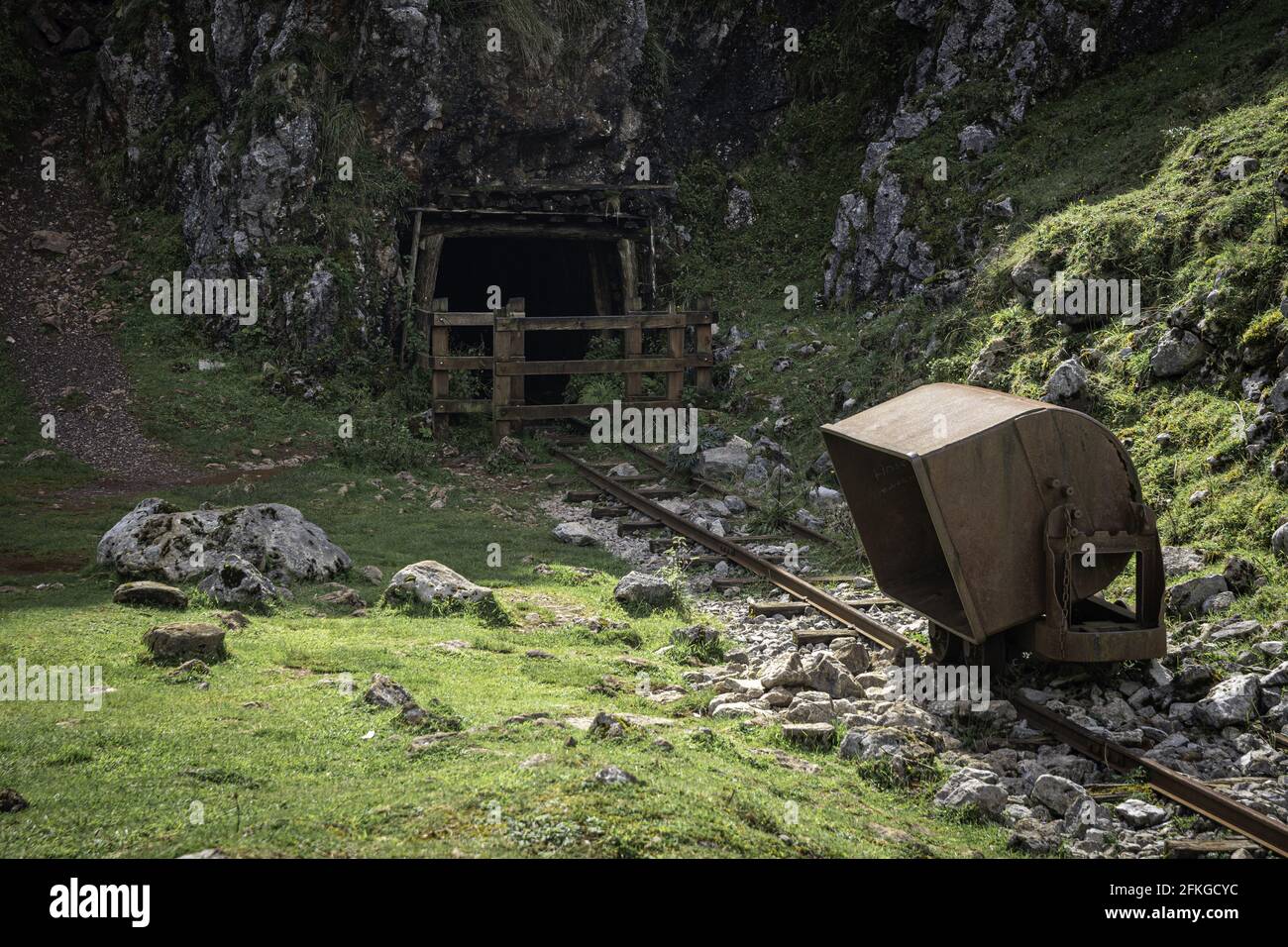 Closeup of an abandoned mine with an old wagon on the tracks surrounded ...