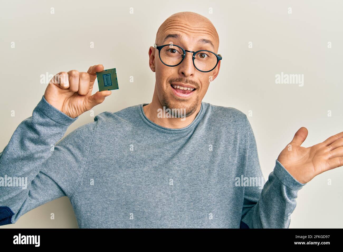 Bald man with beard holding cpu computer processor celebrating ...