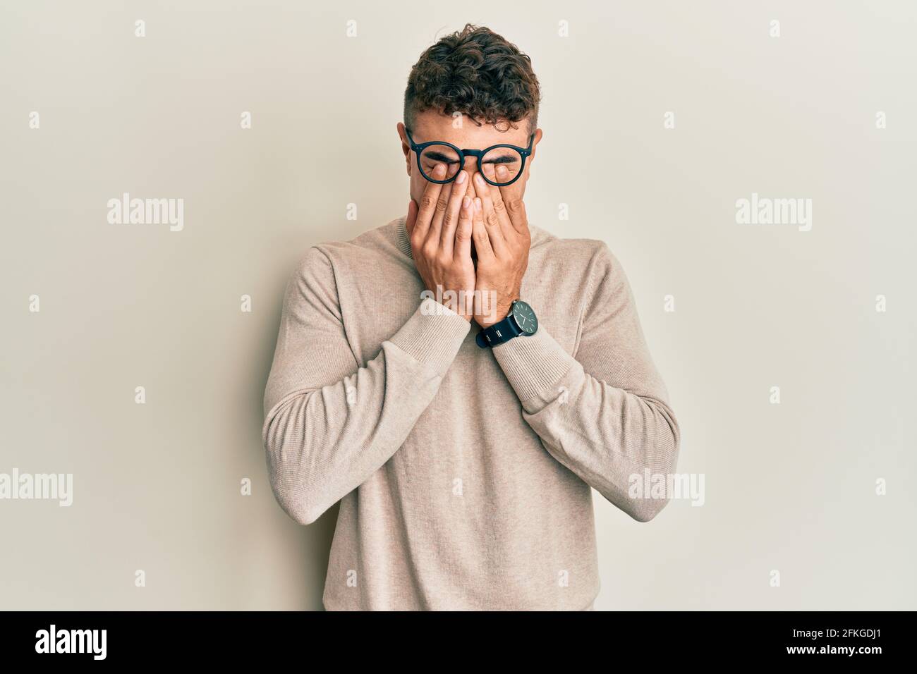 Hispanic young man wearing casual turtleneck sweater rubbing eyes for ...
