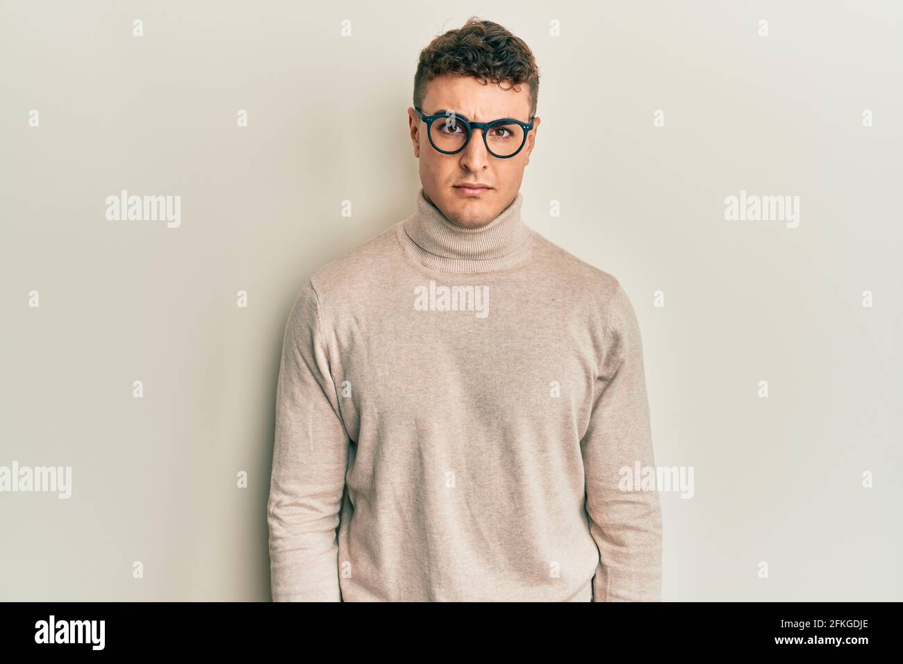 Hispanic young man wearing casual turtleneck sweater skeptic and ...