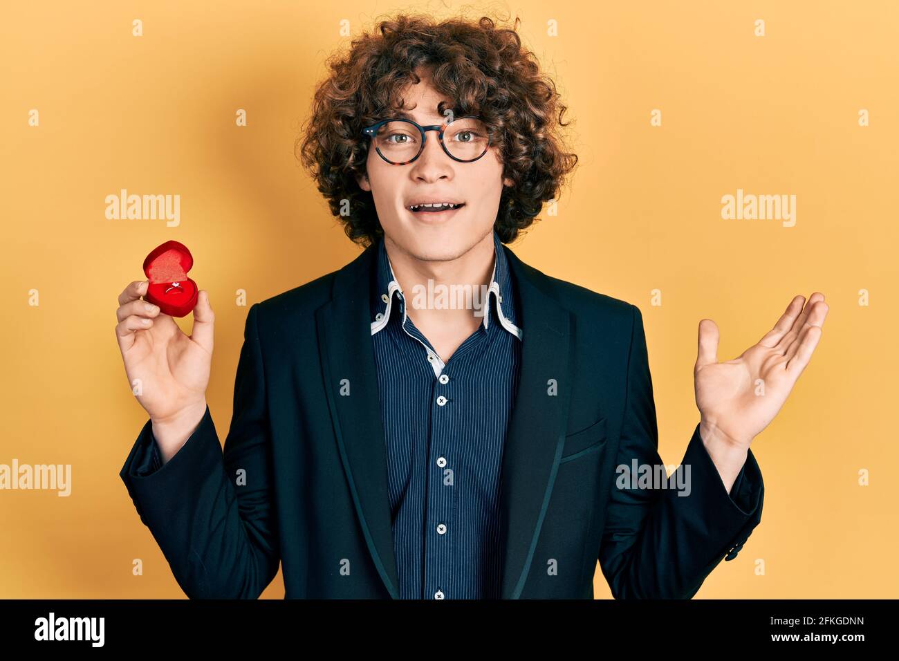Handsome young man holding engagement ring for proposal celebrating ...