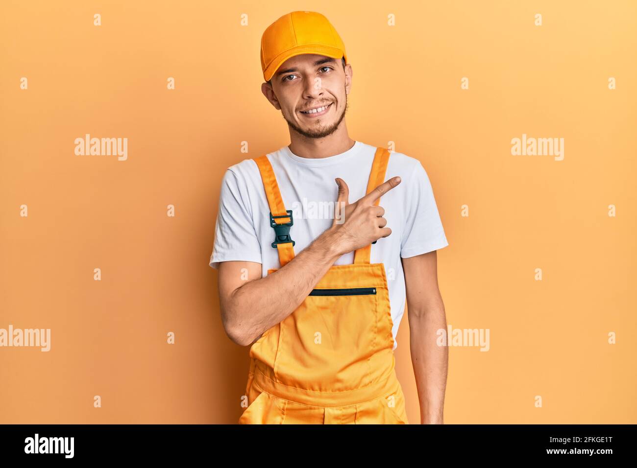 Hispanic young man wearing handyman uniform cheerful with a smile on ...