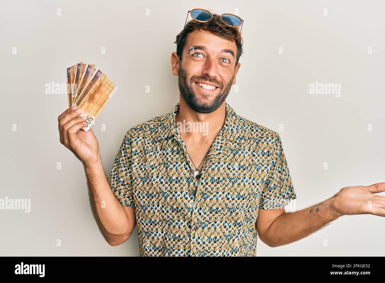 Handsome man with beard holding 500 norwegian krone banknotes ...