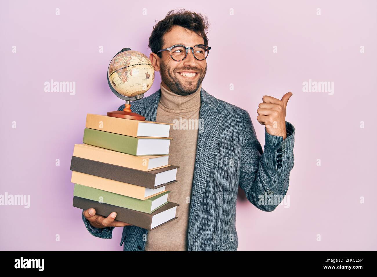 Handsome man with beard geography teacher pointing thumb up to the side ...