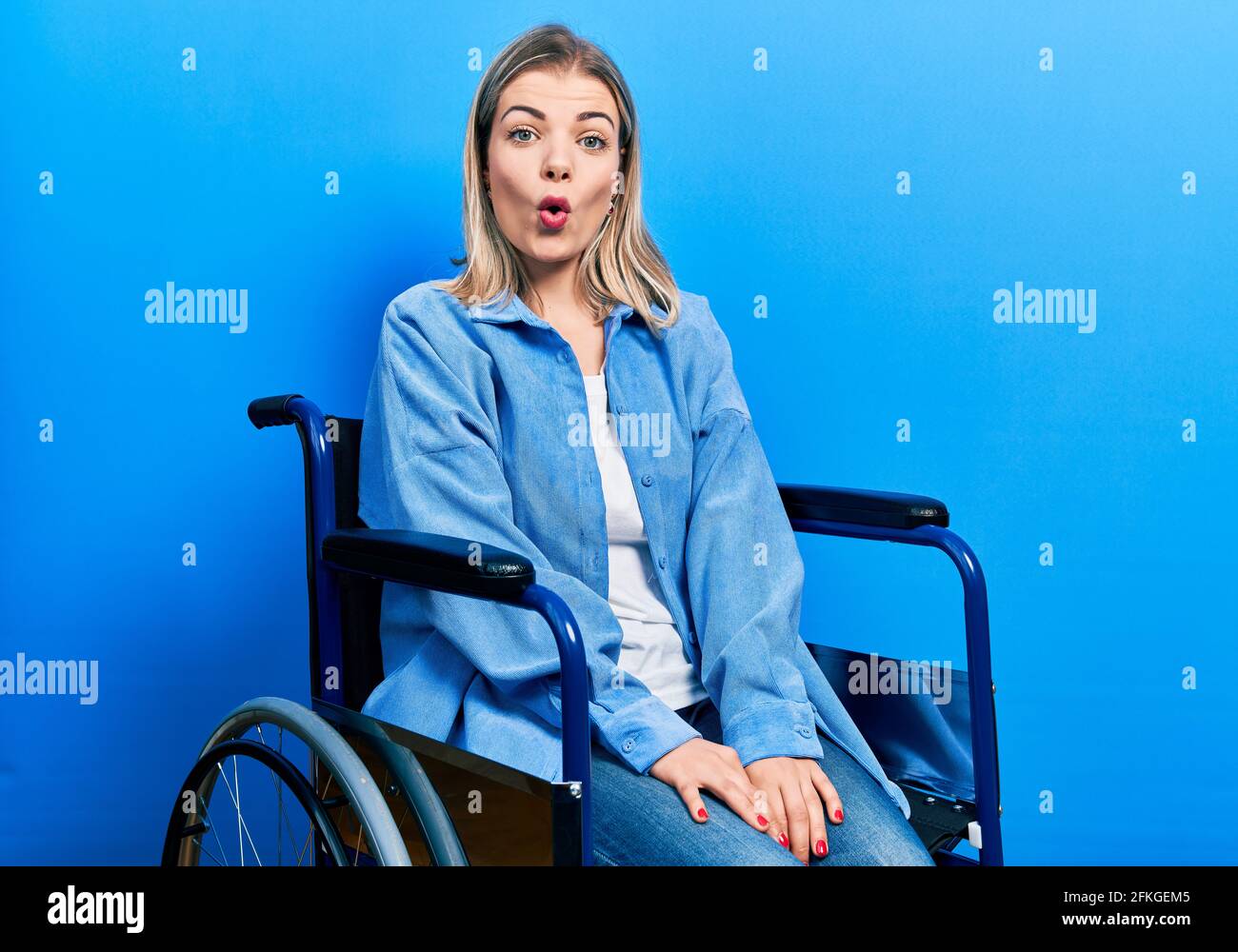 Beautiful caucasian woman sitting on wheelchair afraid and shocked with ...