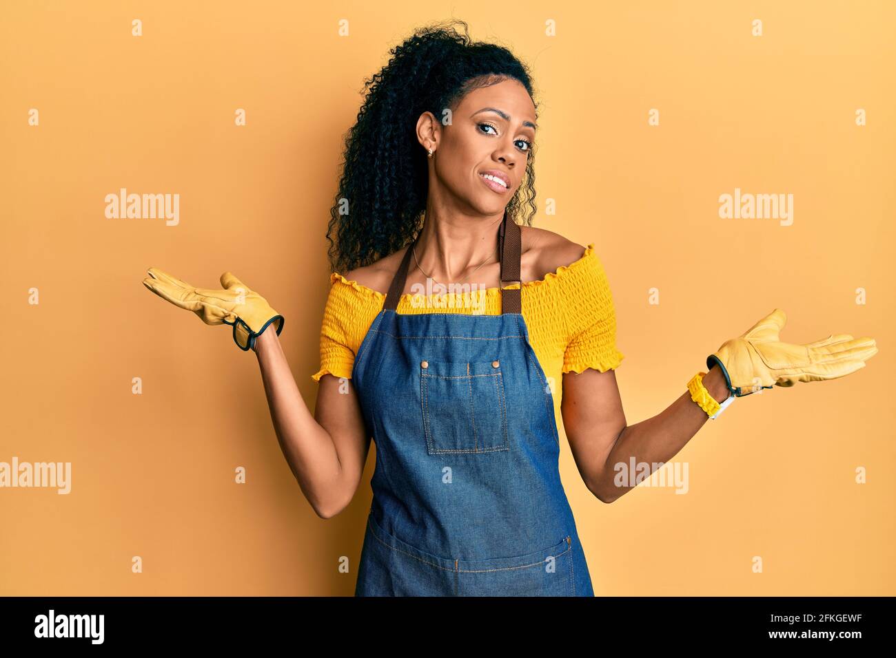 Middle age african american woman wearing professional apron clueless ...