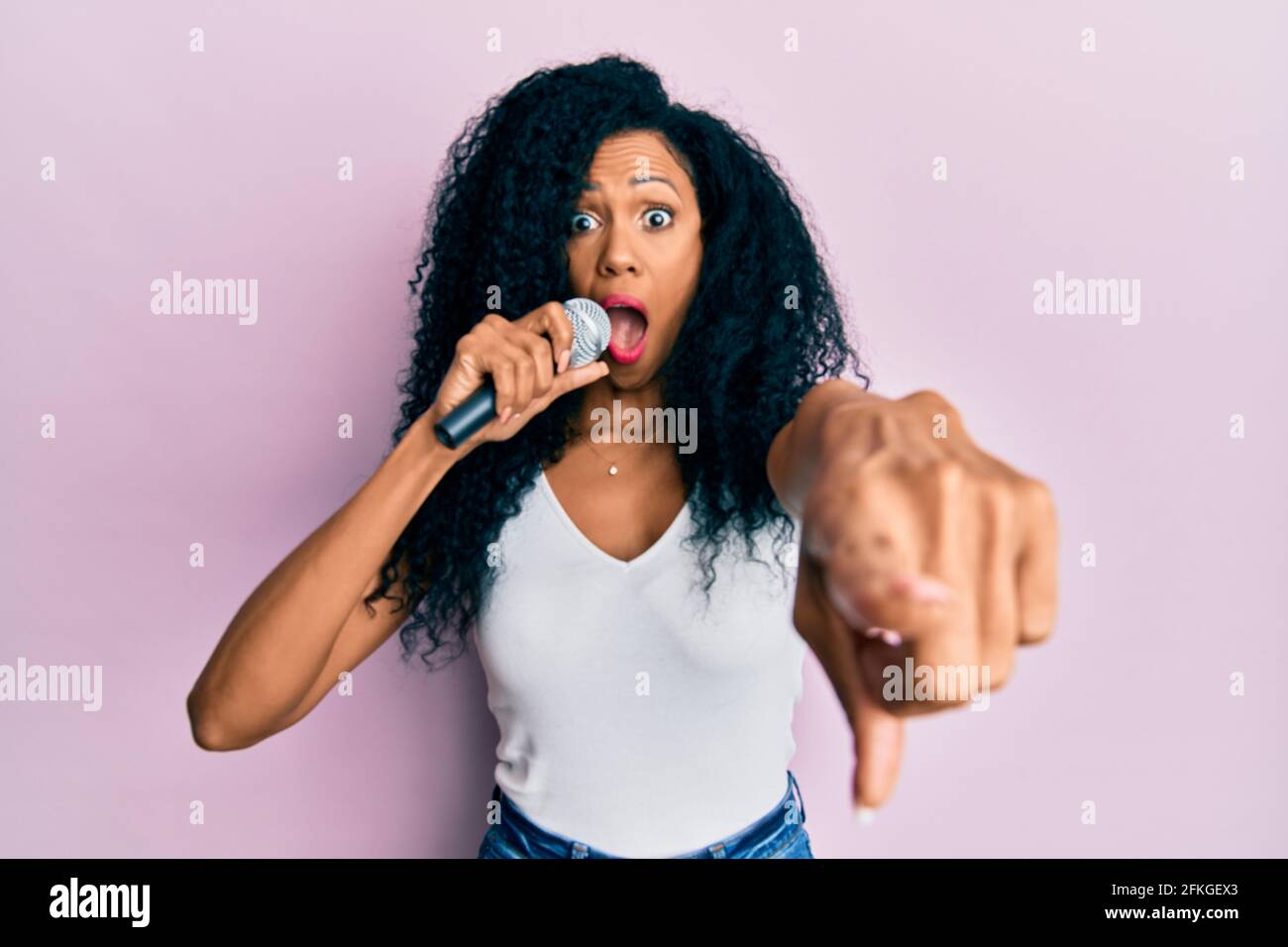 Middle Age African American Woman Singing Song Using Microphone