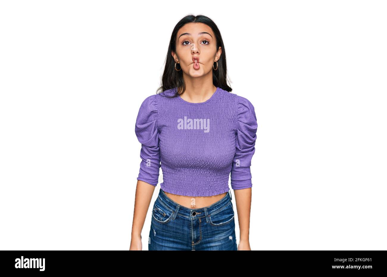 Young hispanic girl wearing casual clothes making fish face with lips ...