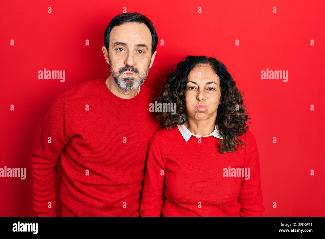 Middle age couple of hispanic woman and man hugging and standing ...