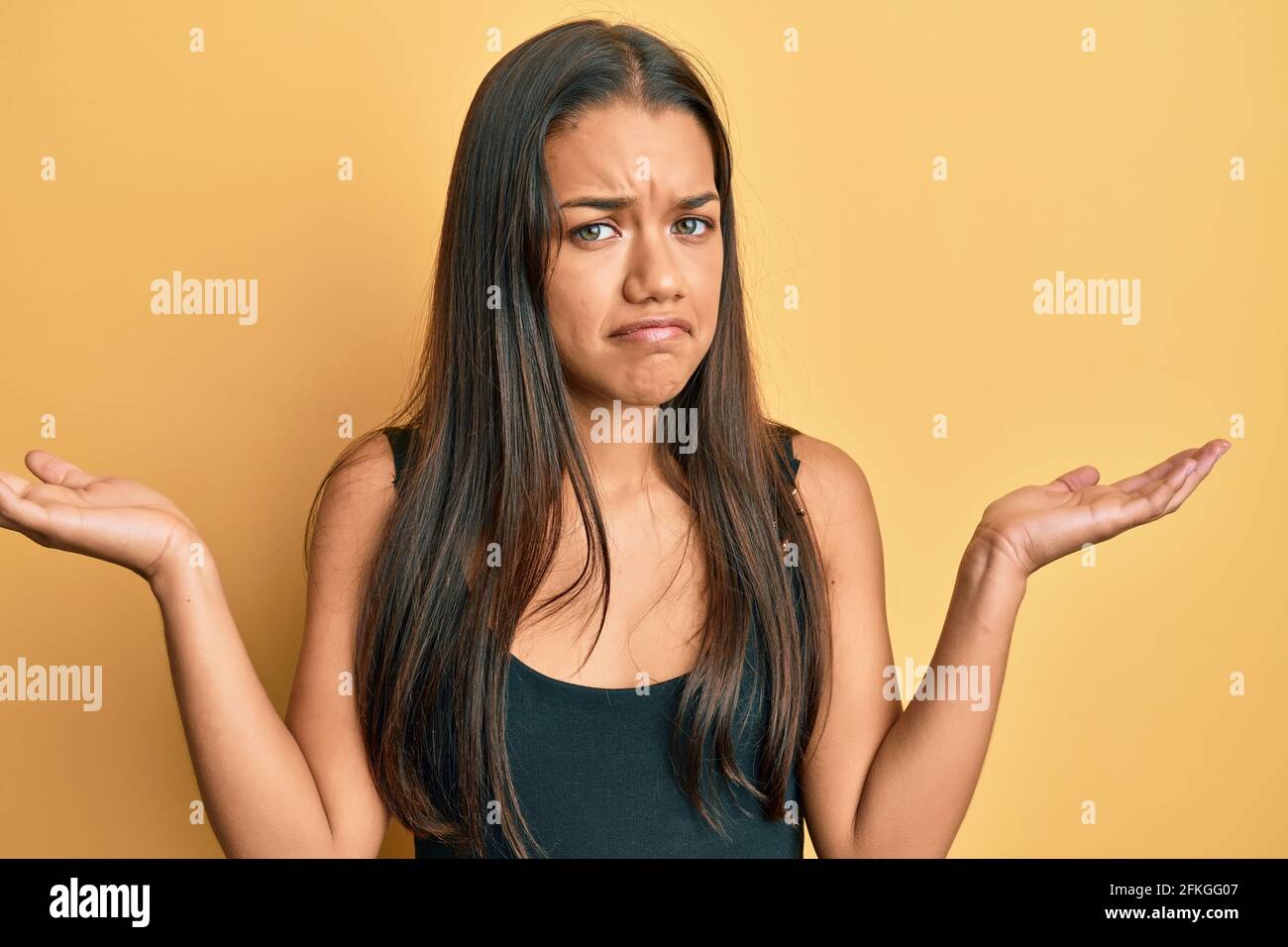 Beautiful hispanic woman wearing casual clothes clueless and confused ...