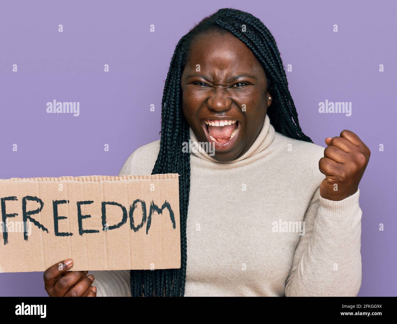 Young black woman with braids holding freedom banner screaming proud ...