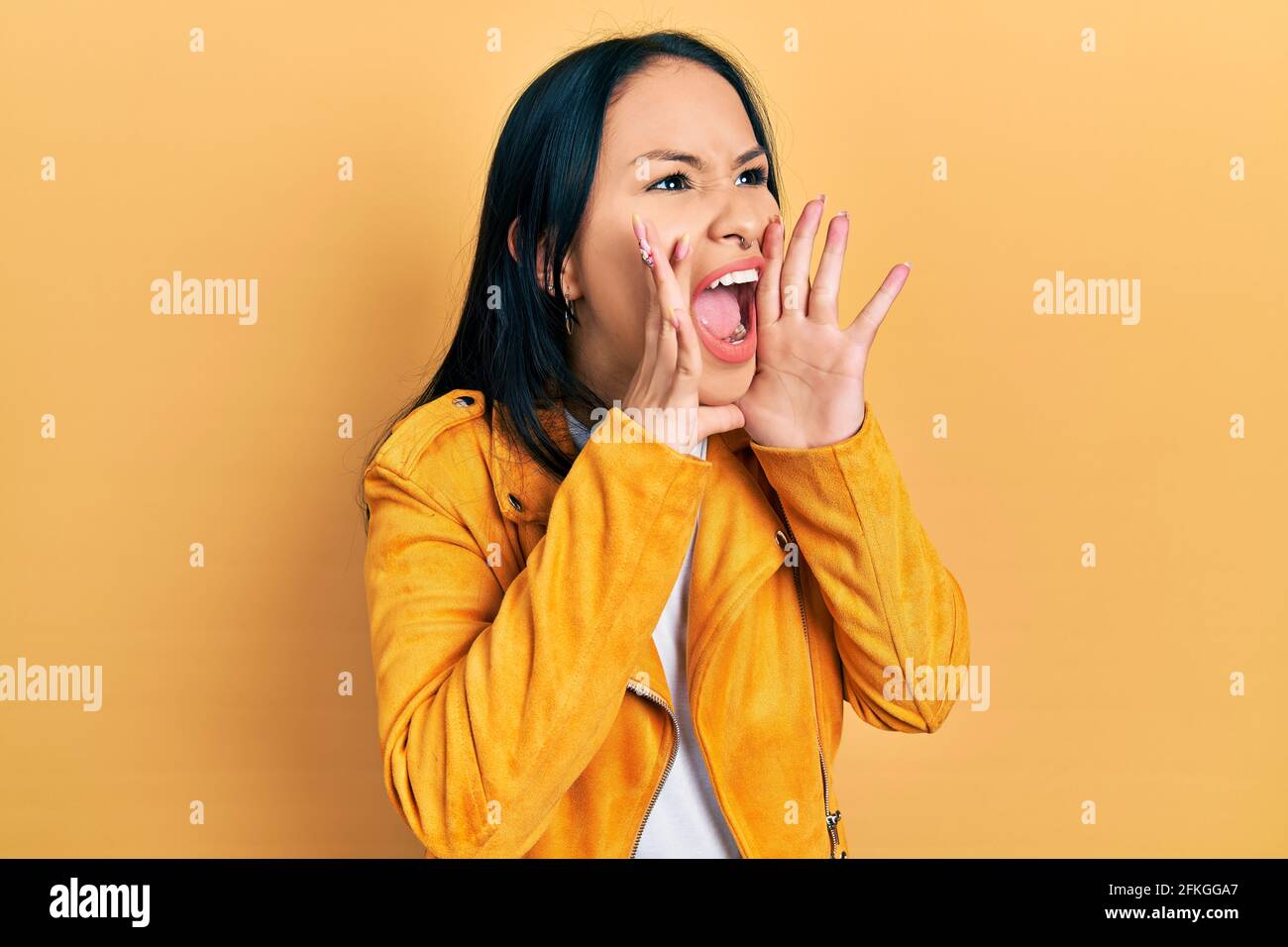 Beautiful hispanic woman with nose piercing wearing yellow leather ...