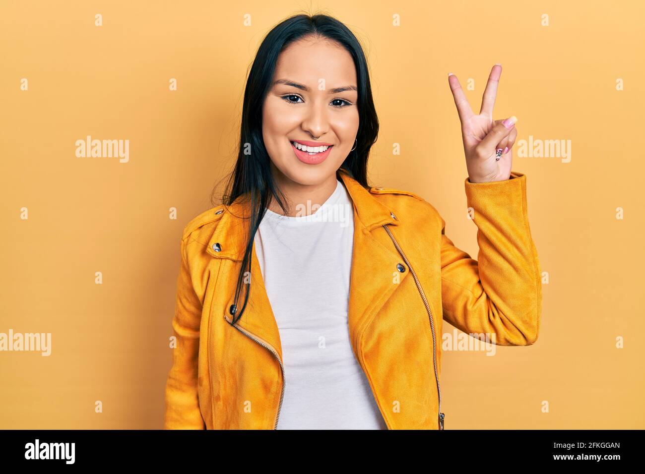 Beautiful hispanic woman with nose piercing wearing yellow leather ...