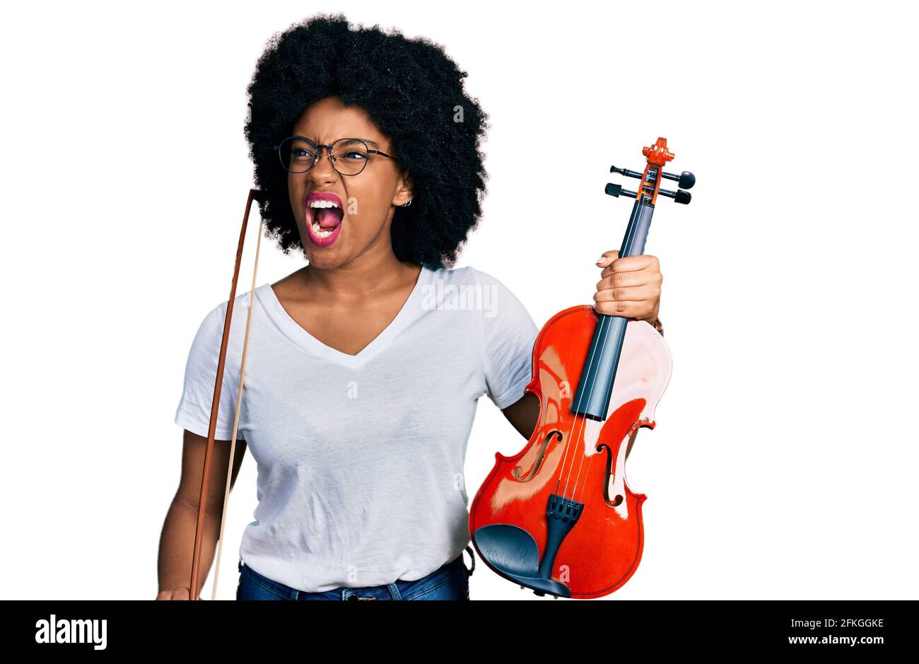 Young african american woman playing violin angry and mad screaming ...