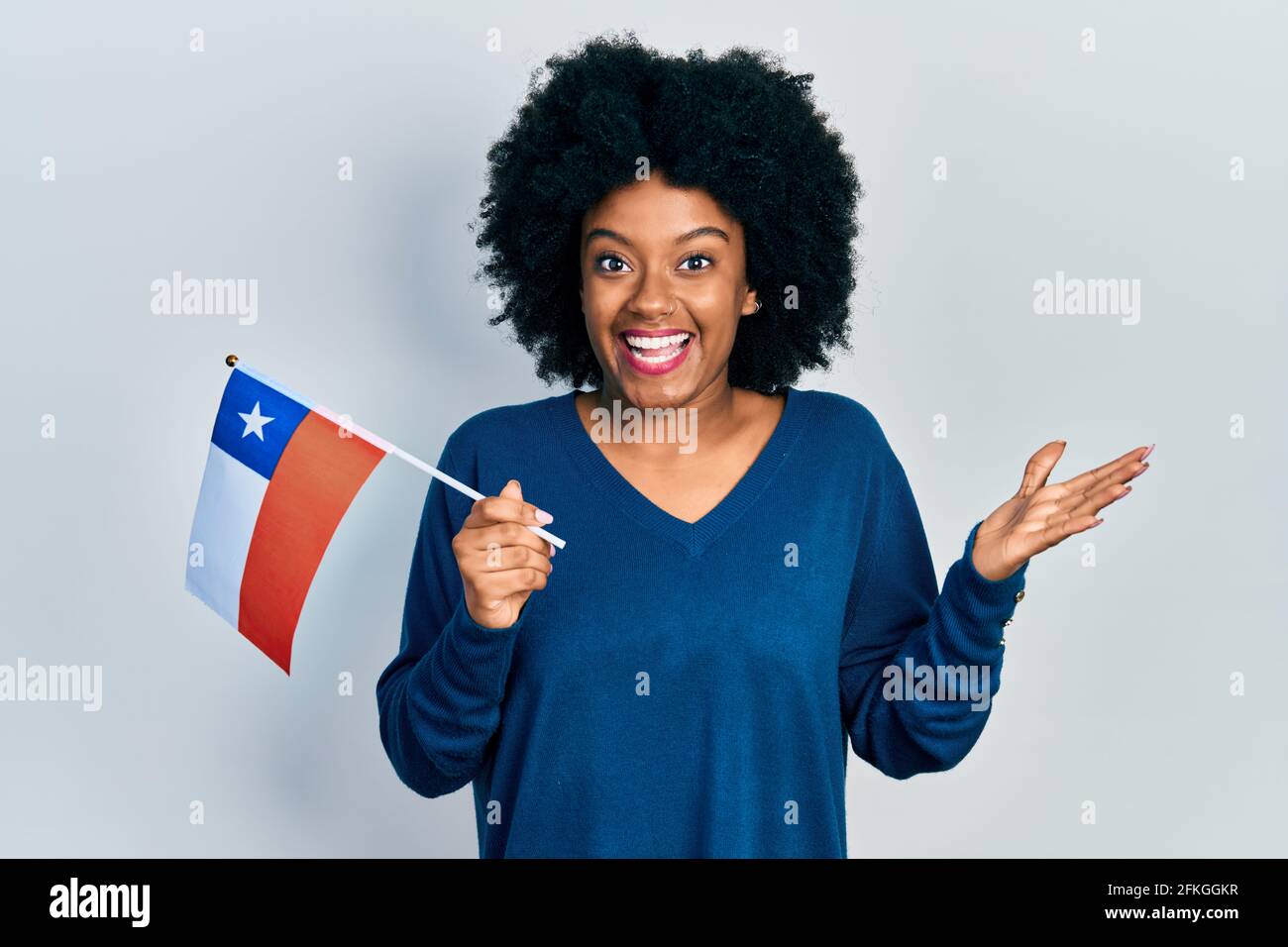Young african american woman holding chile flag celebrating achievement ...