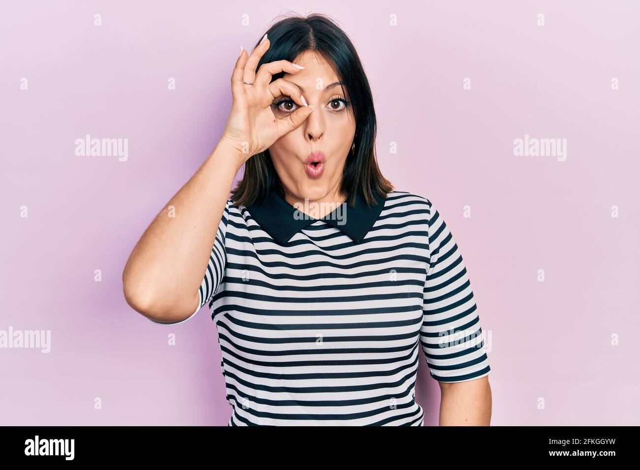 Young hispanic woman wearing casual clothes doing ok gesture shocked ...