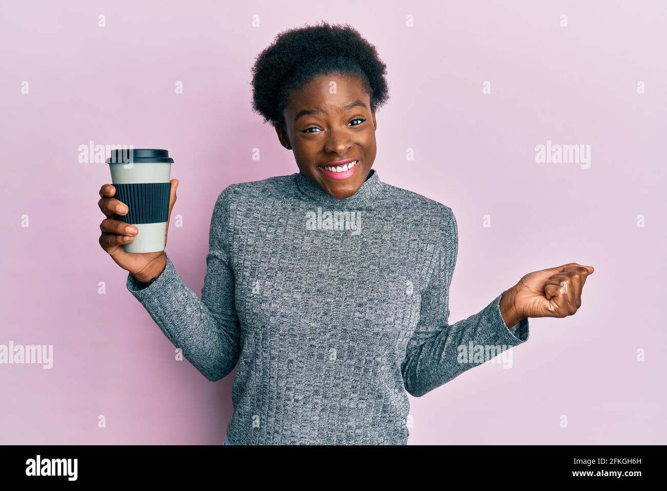 Young african american girl holding take away coffee screaming proud ...