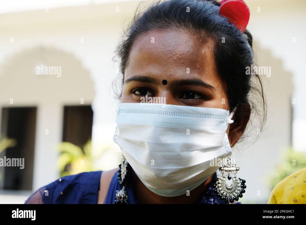 Portrait of a young Indian female wearing a medical face mask looking ...