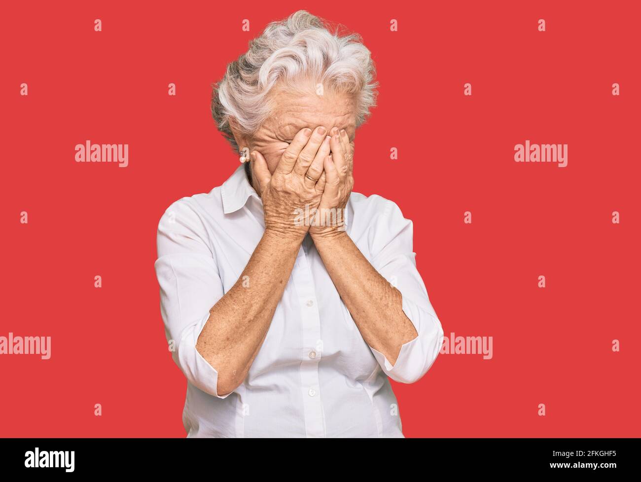 Senior grey-haired woman wearing casual clothes with sad expression ...