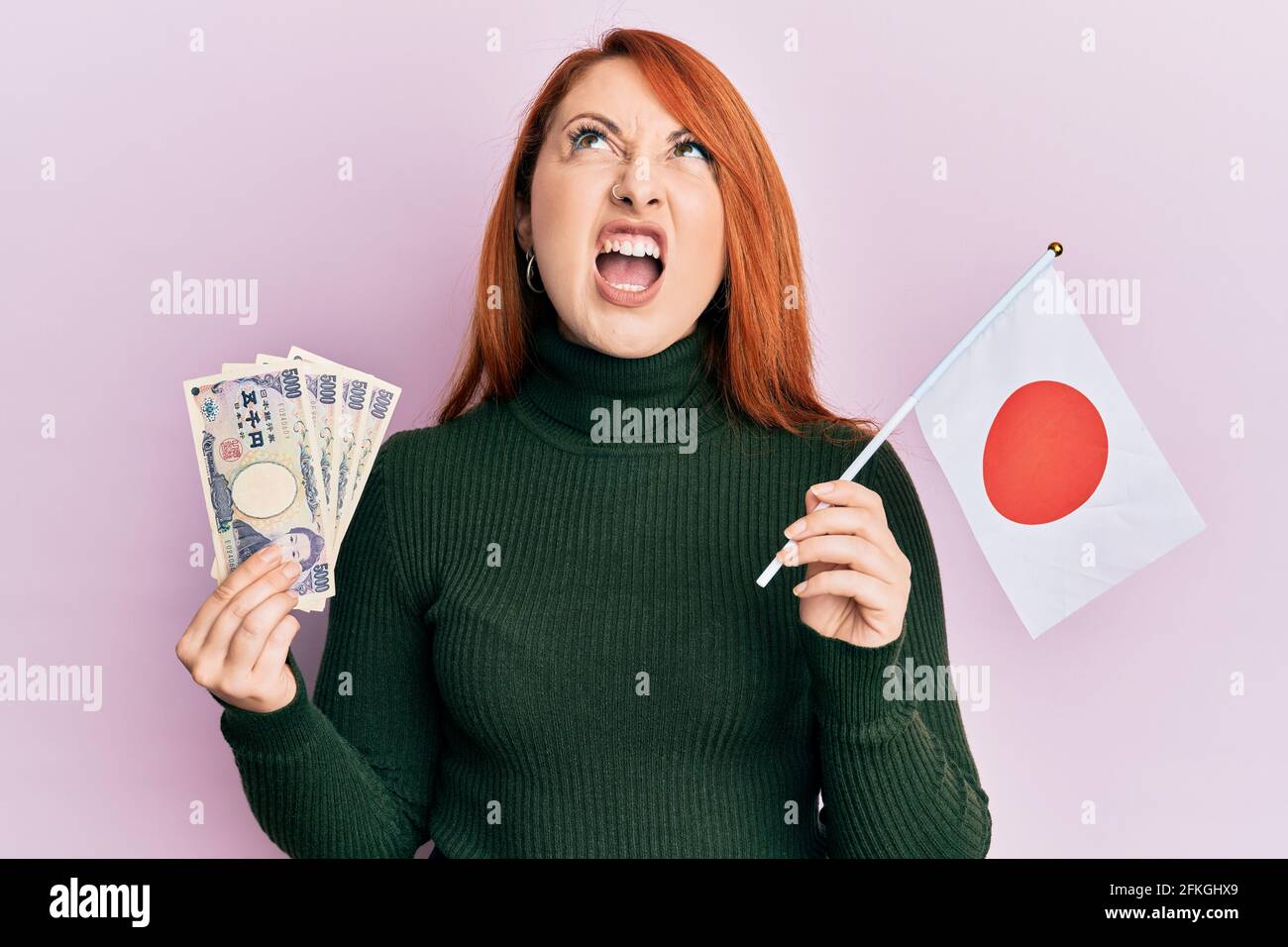 Beautiful redhead woman holding 5000 japanese yen banknotes and japan ...