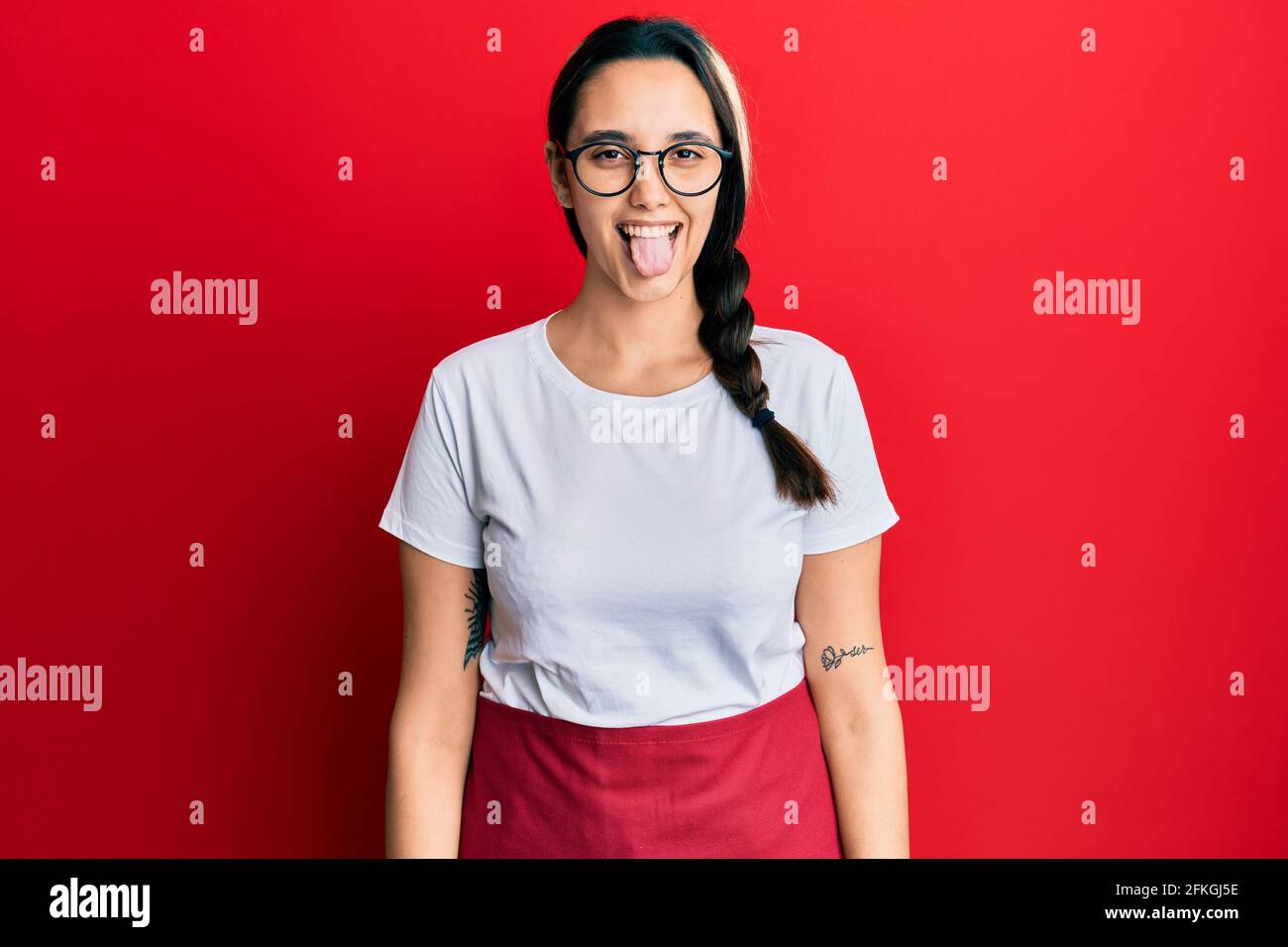 Young hispanic woman wearing professional waitress apron sticking ...
