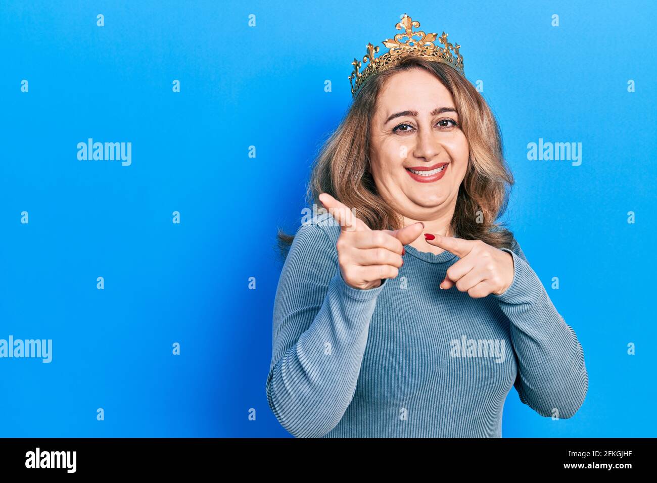Middle age caucasian woman wearing queen crown pointing fingers to ...
