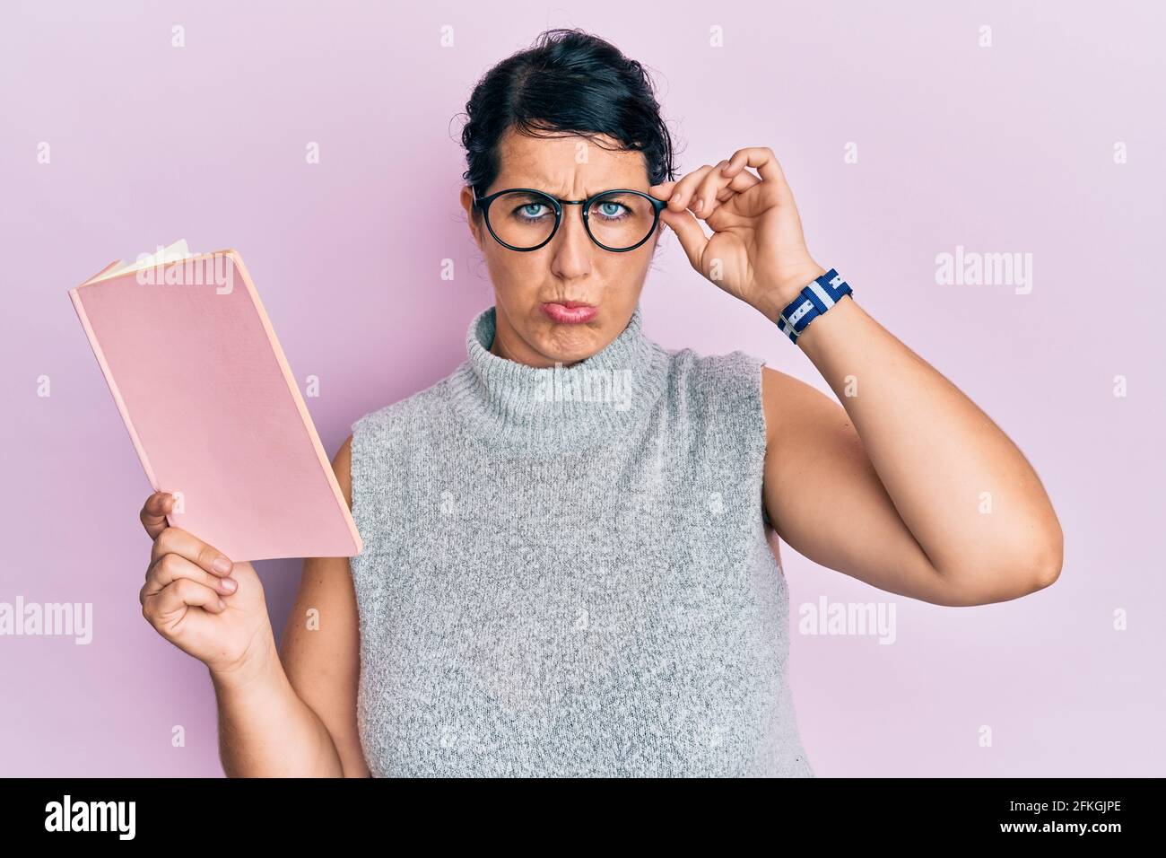 Plus size brunette woman reading a book wearing glasses depressed and ...