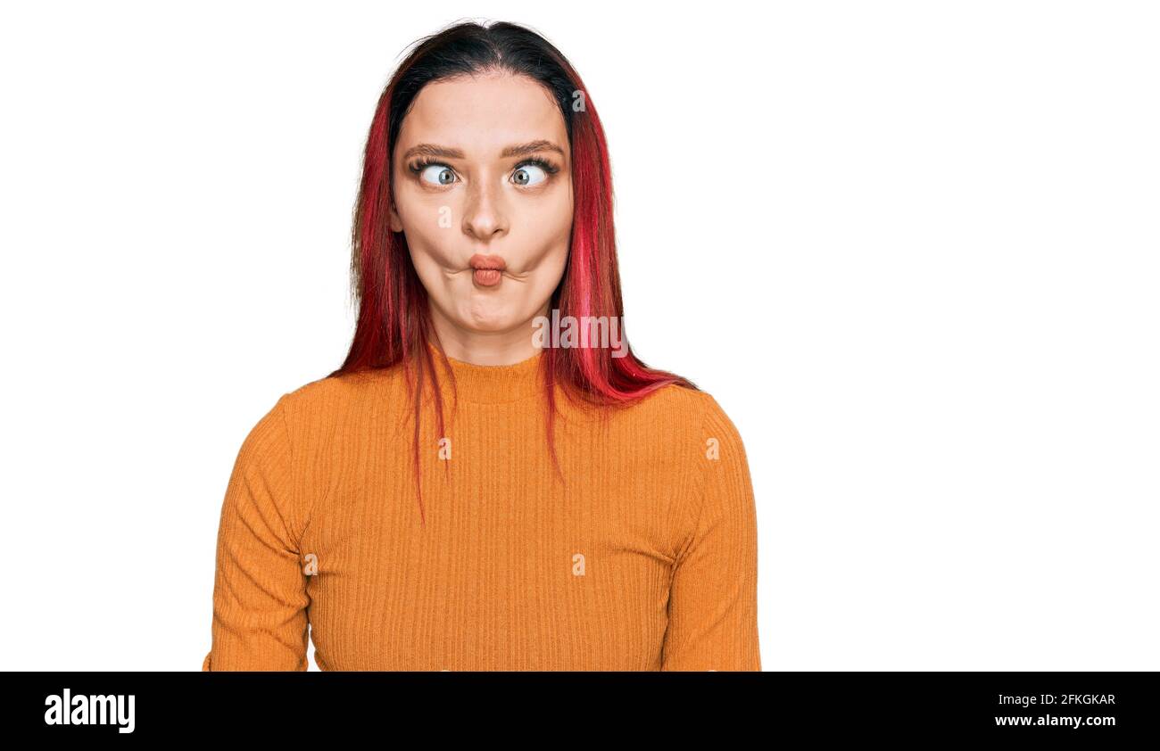 Young caucasian woman wearing casual clothes making fish face with lips ...