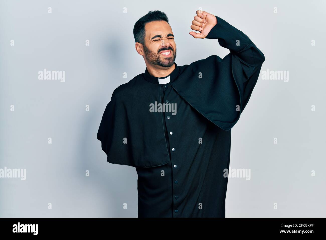 Handsome hispanic man with beard wearing catholic priest robe ...