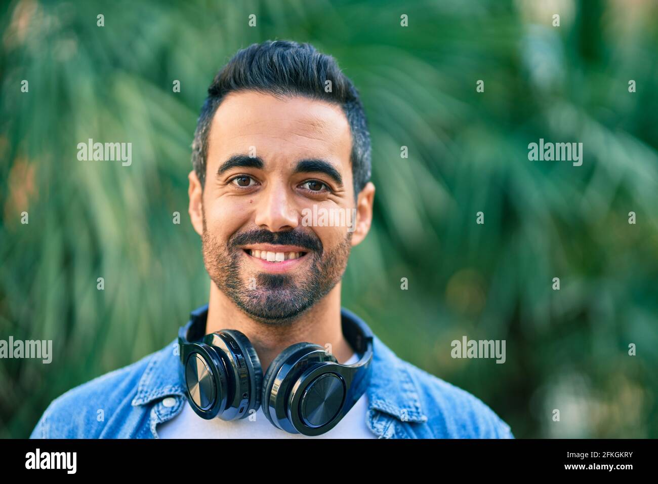 Young hispanic man smiling happy using headphones at the city Stock ...