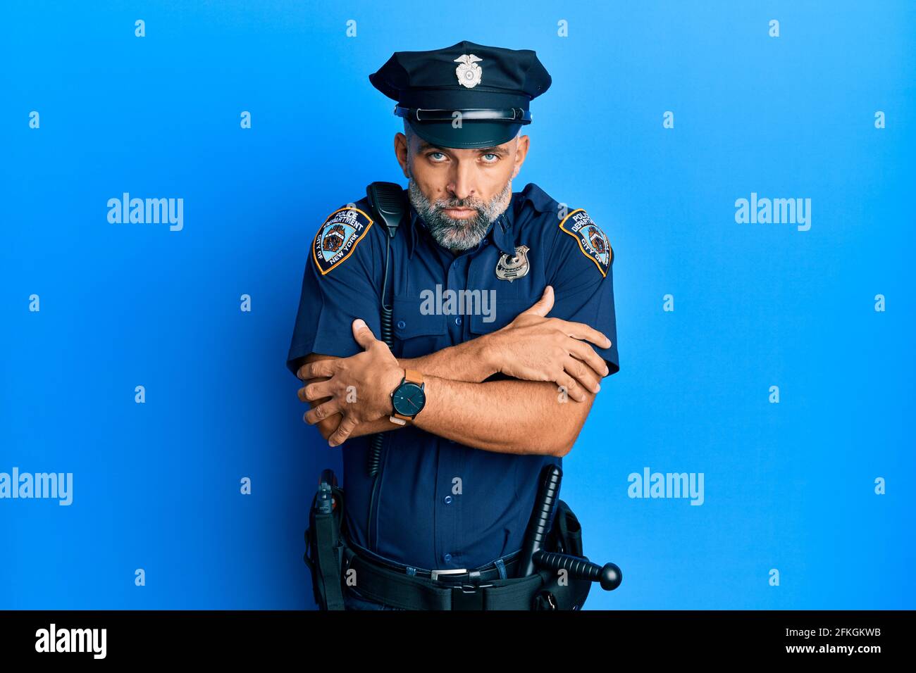 Middle age handsome man wearing police uniform shaking and freezing for ...