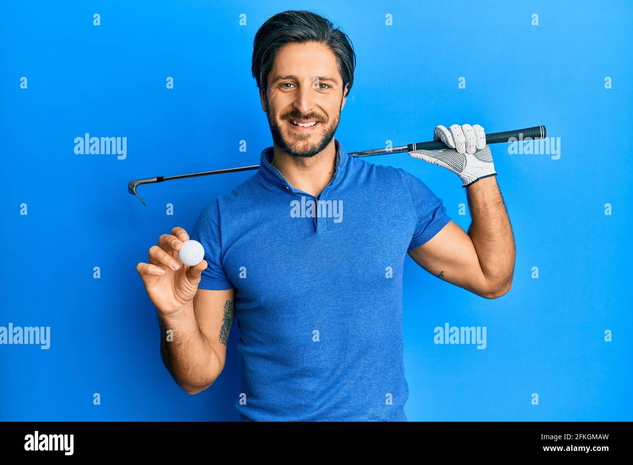 Young hispanic man holding golf ball smiling with a happy and cool ...