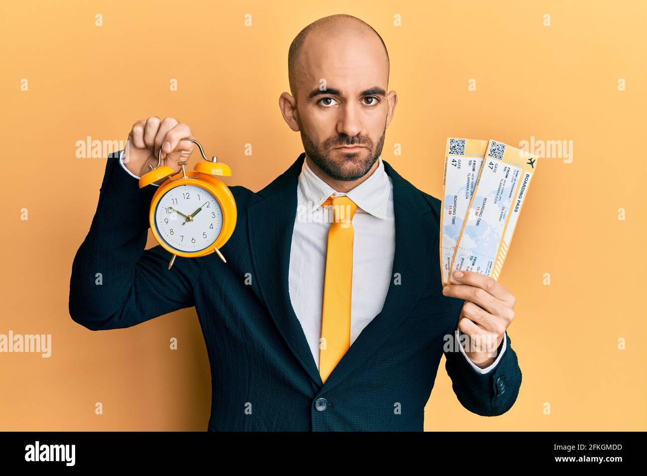 Young hispanic business man holding boarding pass and alarm clock ...