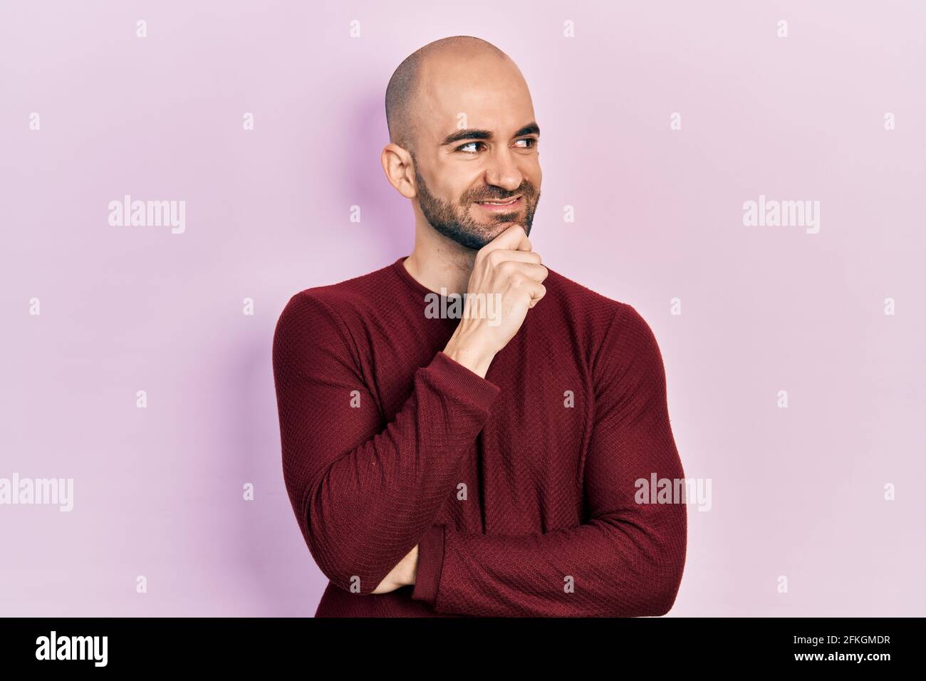 Young bald man wearing casual clothes with hand on chin thinking about ...