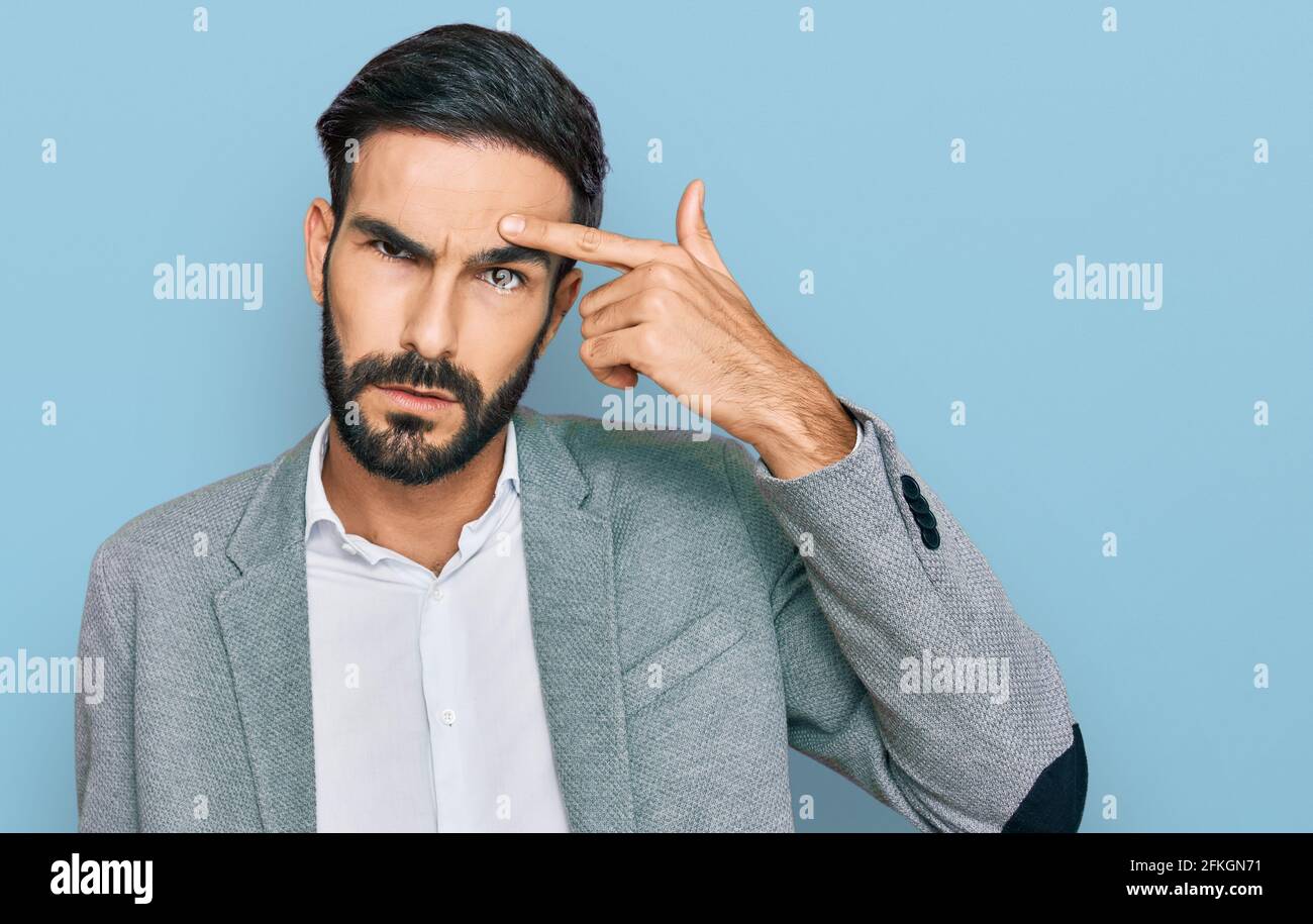Young hispanic man wearing business clothes pointing unhappy to pimple ...